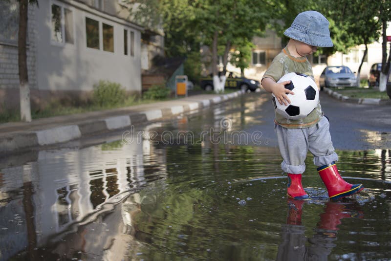 Happy Boy Play in Puddle with Ball Outdoors Stock Photo - Image of baby ...