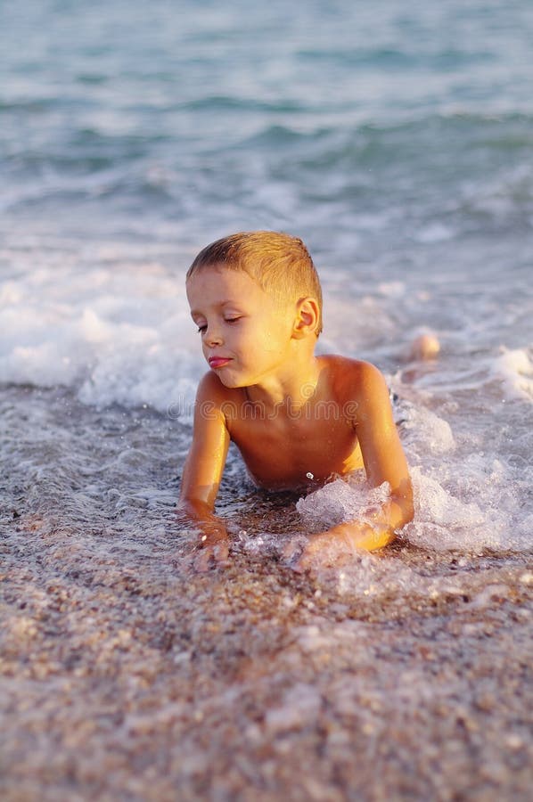 A Happy Boy is Playing in the Waves on the Beach. Stock Image - Image ... A Happy Boy is Playing in the Waves on the Beach. Stock Image - Image ...