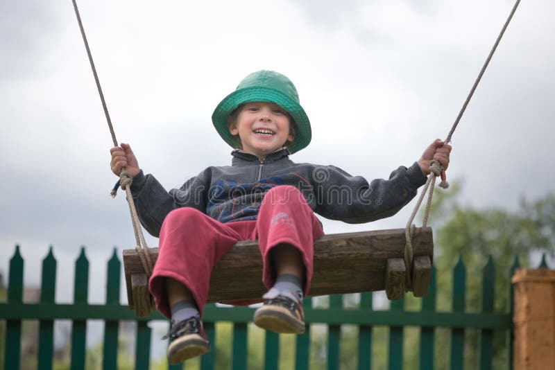 Happy Boy is Riding on a Swing. Stock Photo - Image of kindergarten ...