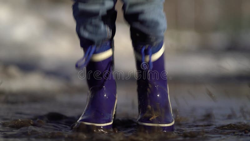 Happy Boy Rubber Boots Have Fun Playing in a Puddle, on Road Stock ...