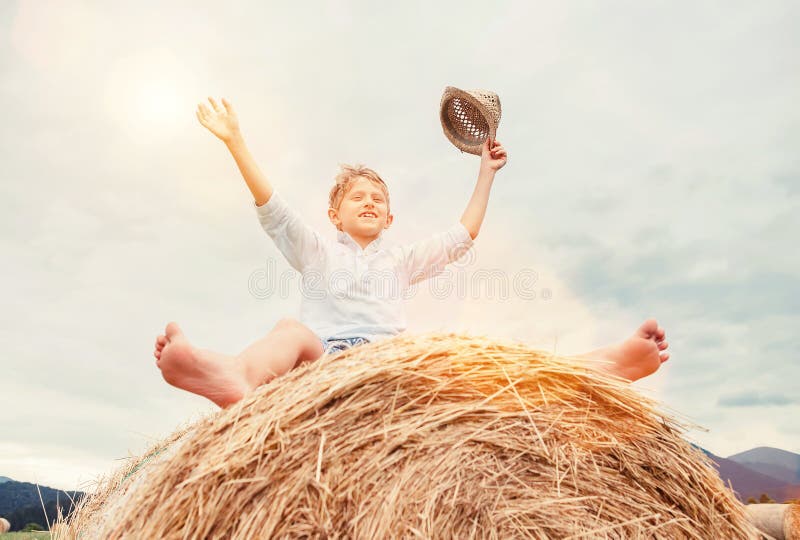 Happy Boy Sits Over Big Rolling Haystack Stock Image - Image of ...