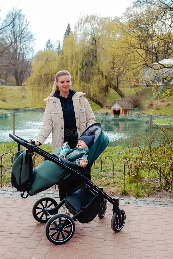 Happy Boy Sitting in a Stroller with Mom Stock Image - Image of ...