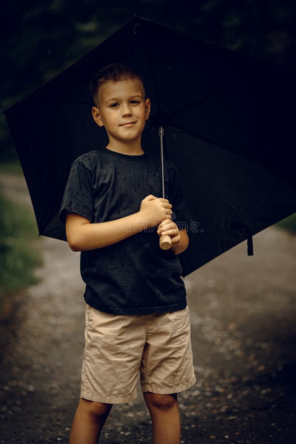 Happy Boy Standing Under an Umbrella during Light Rain Stock Image ...