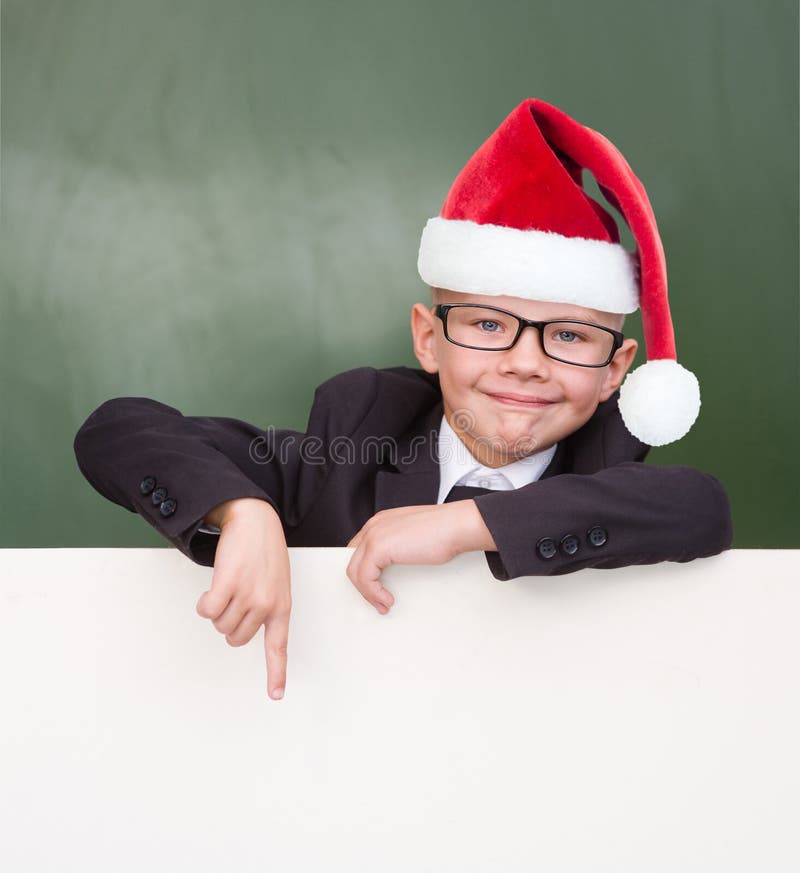 Happy Boy in a Suit with Red Christmas Hat Pointing Down at Blank ...