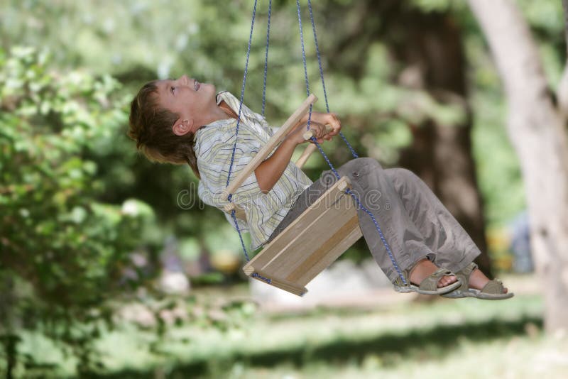 Happy boy on swing in park stock photo. Image of excitement - 26278112