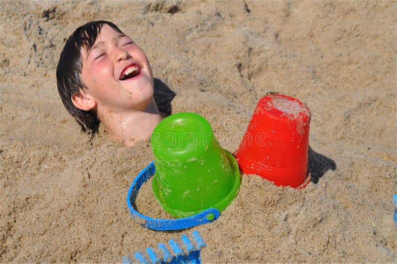 Happy Boy Under Sand stock image. Image of playing, play - 28390197