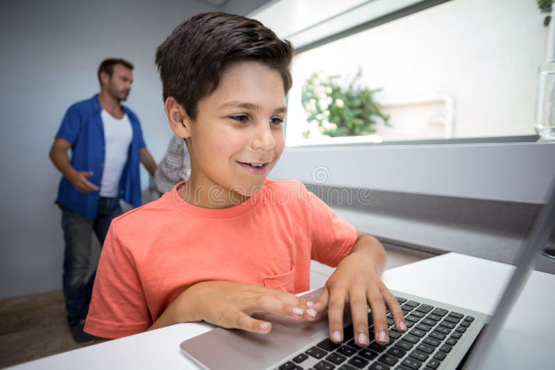 Happy boy using laptop stock image. Image of comfortable - 68292491