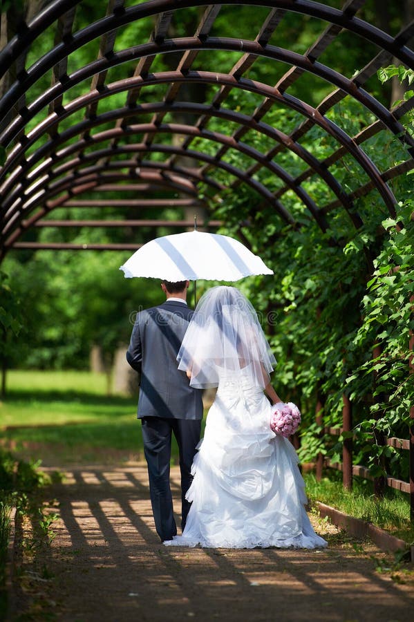 Bride and Groom Goes Along the Arch Stock Photo - Image of shadow ...