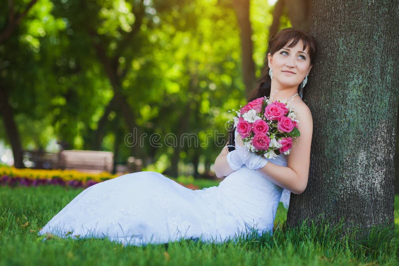 Happy Bride in White Dress Sitting Under a Tree Stock Image - Image of ...