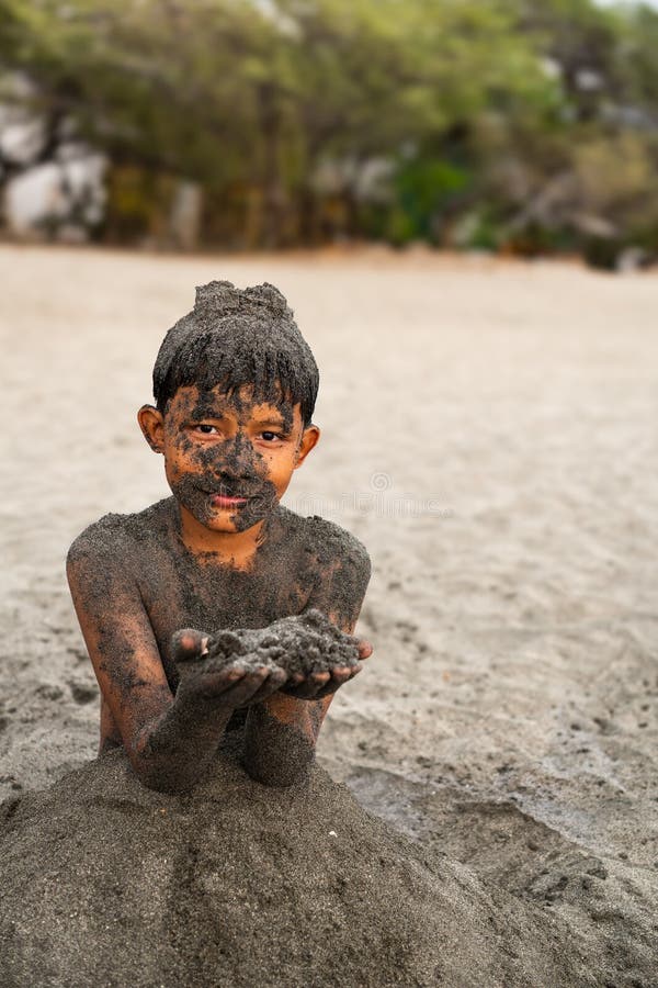 Happy Brown-skinned Latino Boy Covered in Sand, Playing on the Beach ...