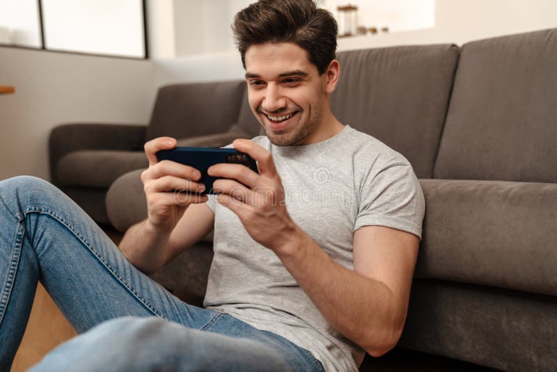 Happy Brunette Guy Playing Video Game on Mobile Phone Stock Image ...