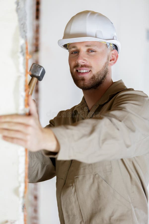 Happy builder hammers wall stock photo. Image of life - 281914130