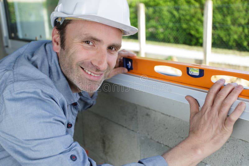 Happy Builder Posing with Spirit Level at Construction Site Stock Image ...