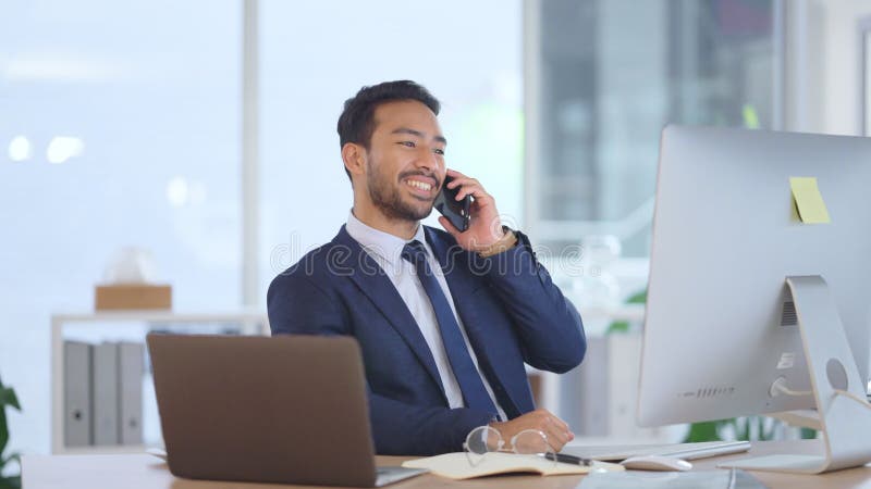 Happy Business Man Talking on His Phone while Working on a Computer and ...