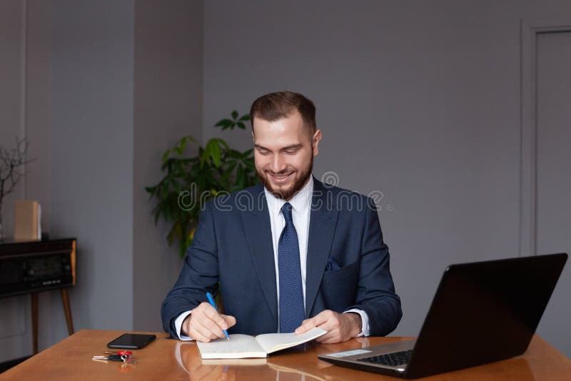 Happy Businessman in Suit is Writing Notes about His Work. Multi ...