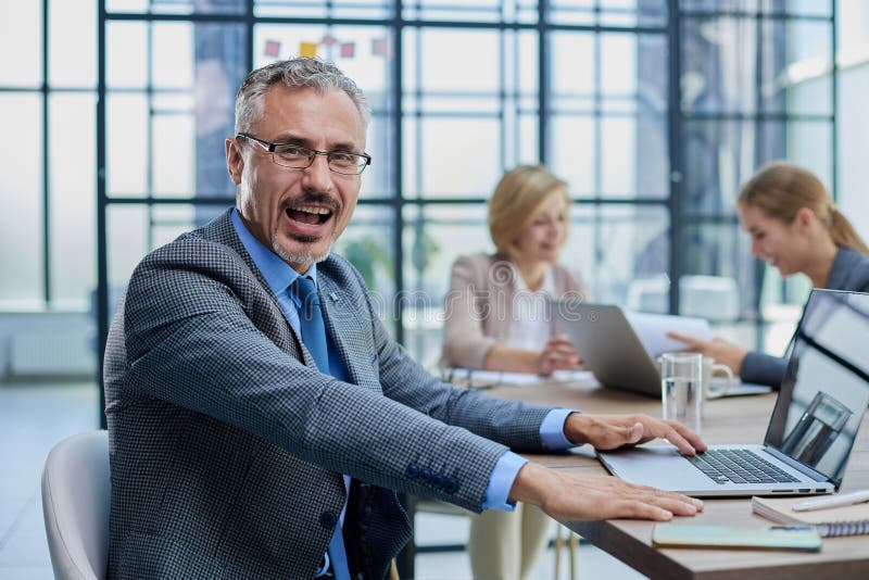 Happy Businessman Wearing Eyeglasses Sitting With Laptop Stock Image