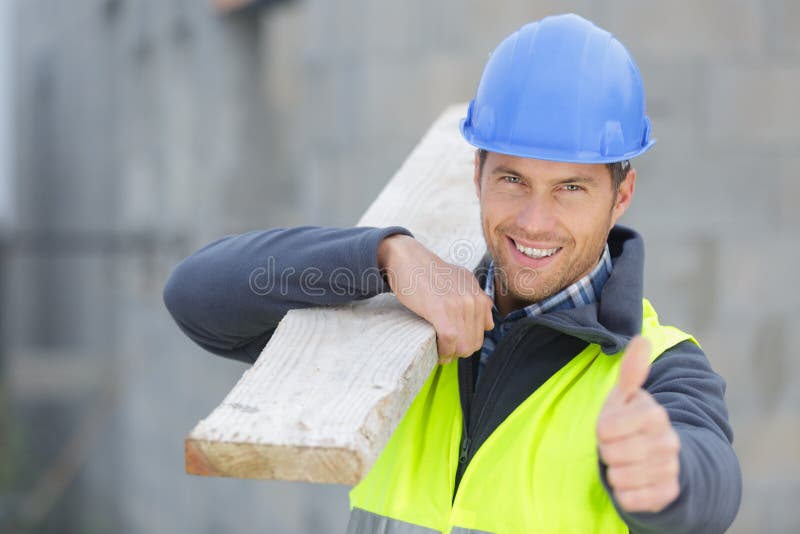 Happy Carpenter Carrying Wooden Planks at Construction Site Stock Photo ...