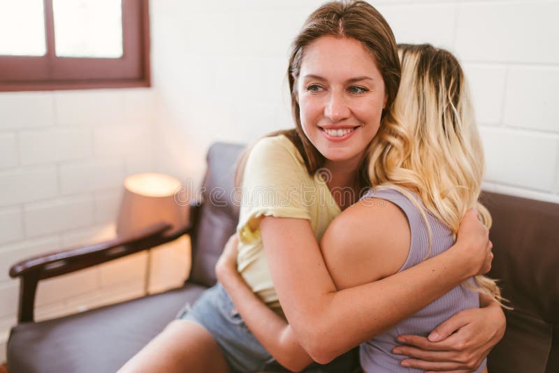 Happy Caucasian Lesbian Couple Cuddling Each Other With A Smile And