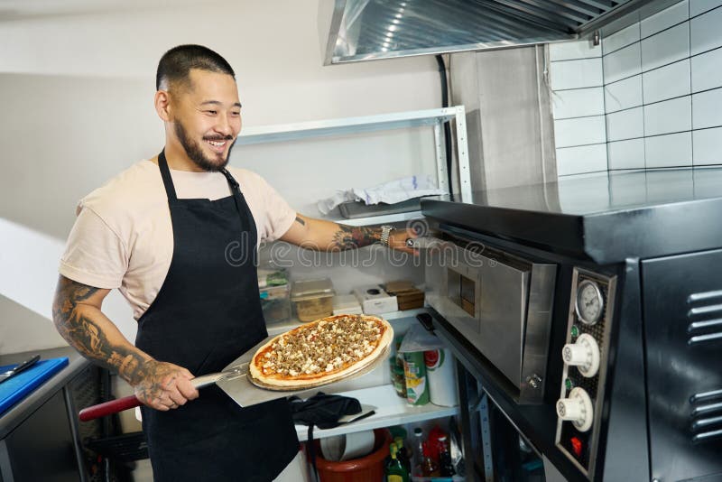 Smiley Young Man Inserting a Handmade Pizza into the Oven Stock Image ...