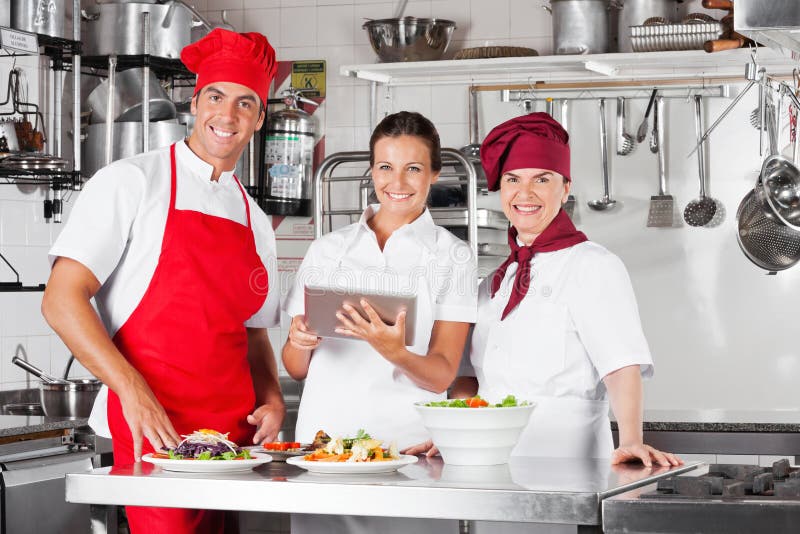 Chefs Using Tablet Computer at Kitchen Counter Stock Photo - Image of ...