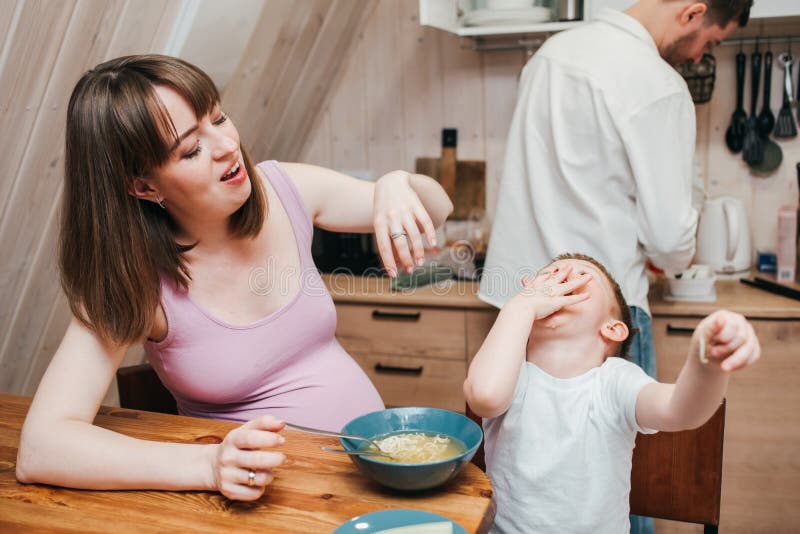 Happy Child Eats Pasta in the Kitchen with Her Family Stock Photo ...