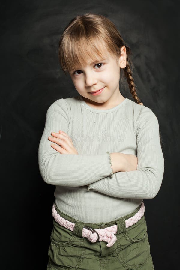 Happy Child Girl Smiling and Standing Arms Crossed on Blackboard ... Happy Child Girl Smiling and Standing Arms Crossed on Blackboard ...