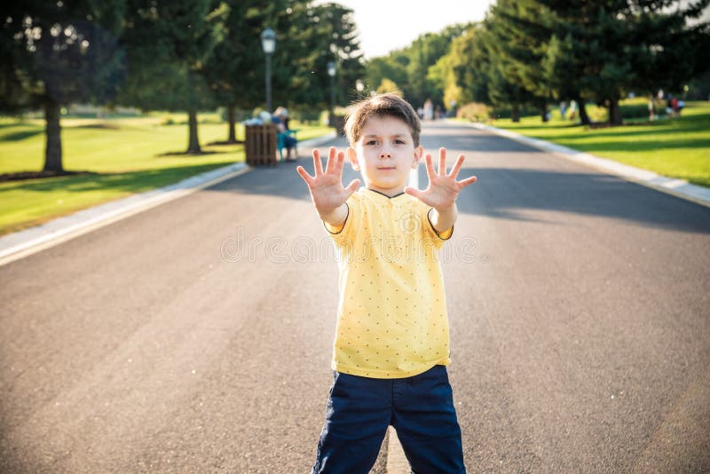 Happy Child Making a Stop Sign with His Hand while Standing at the Road ...