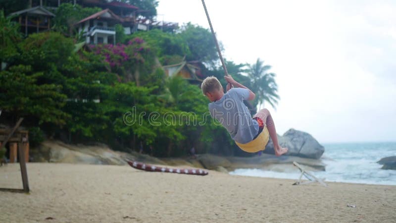 The Happy Child Swinging on a Swing on the Beach Stock Footage - Video ...