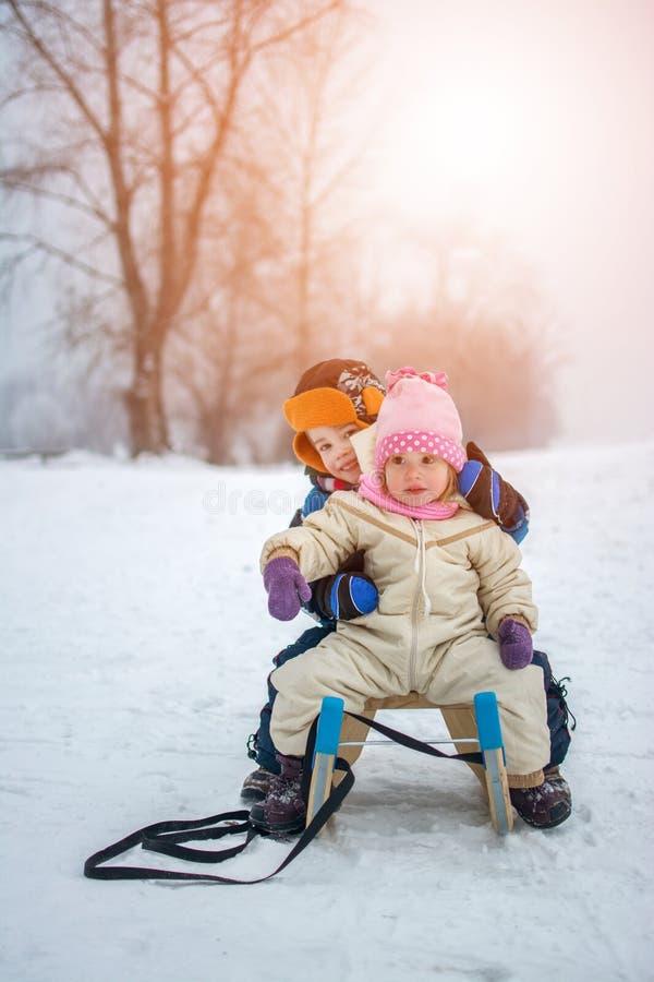 Happy Children Having Sled Ride during Cold Winter Day in the Park ...