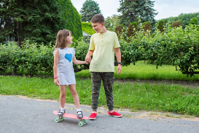 Happy Children Play in the Park and Ride on a Skateboard Stock Photo ...