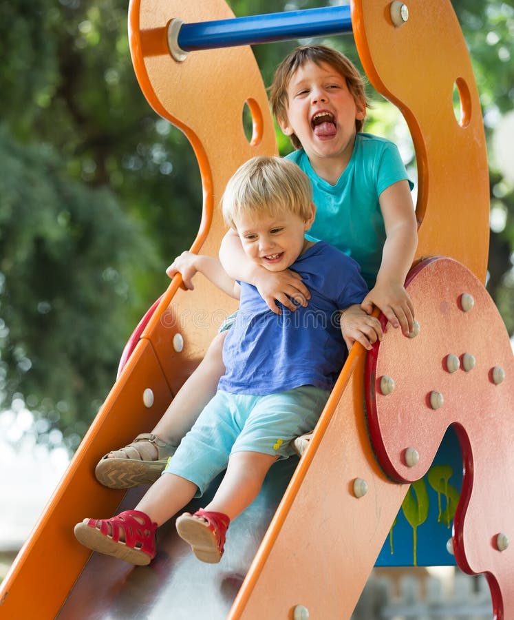 Two Happy Children on Slide at Playground Stock Image - Image of family ...