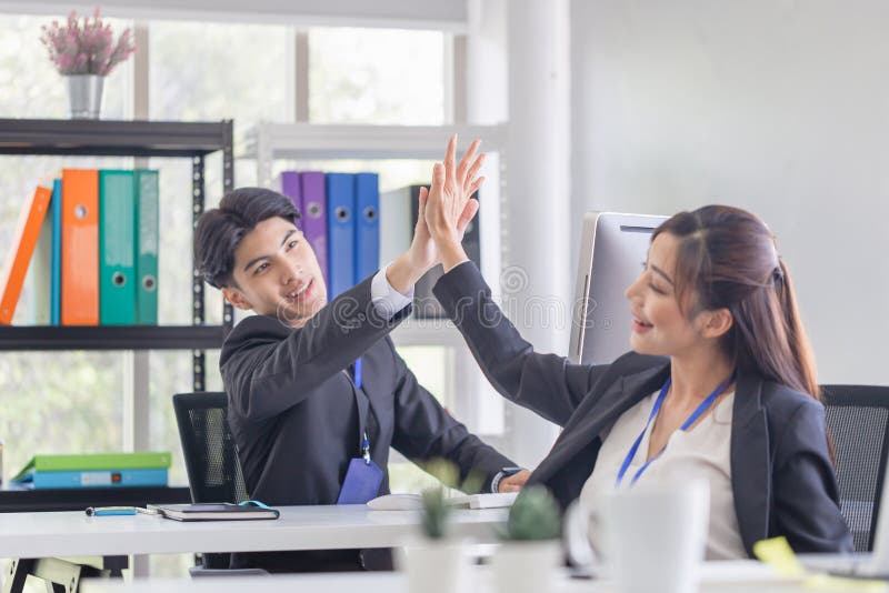 Happy Colleagues Giving High Five while Sitting at the Office Stock ...