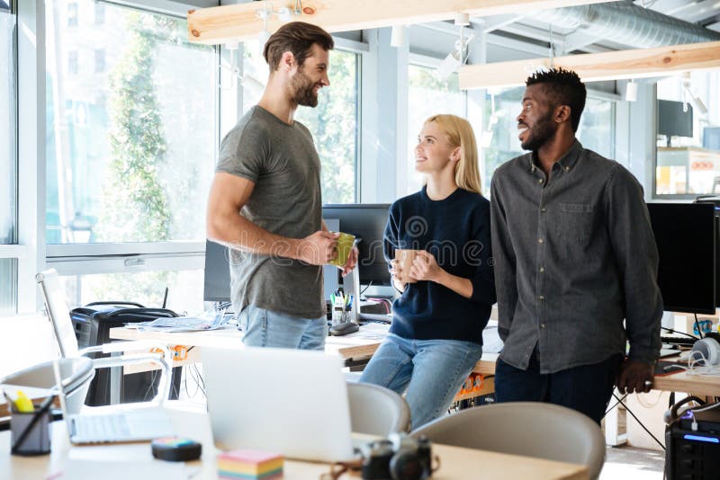 Happy Colleagues Sitting in Office Talking with Each Other. Stock Photo ...