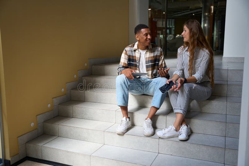 Happy Colleagues Sitting on the Steps and Talking Stock Image - Image ...