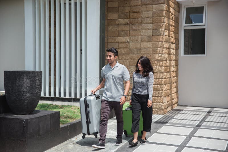 Happy Couple Carrying Their Suitcase Stock Photo - Image of happy ...