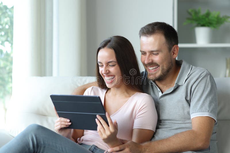 Happy Couple Checking Funny Content on Tablet at Home Stock Photo ...
