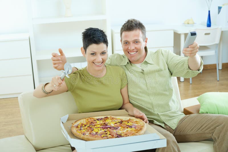 Happy couple eating pizza stock photo. Image of color - 18216144