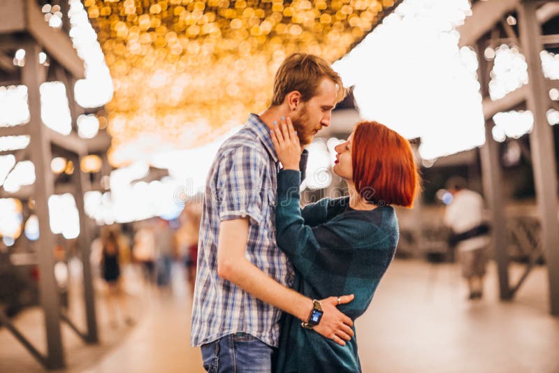 Happy Couple Embracing in the Evening on a Light Garlands Stock Photo ...