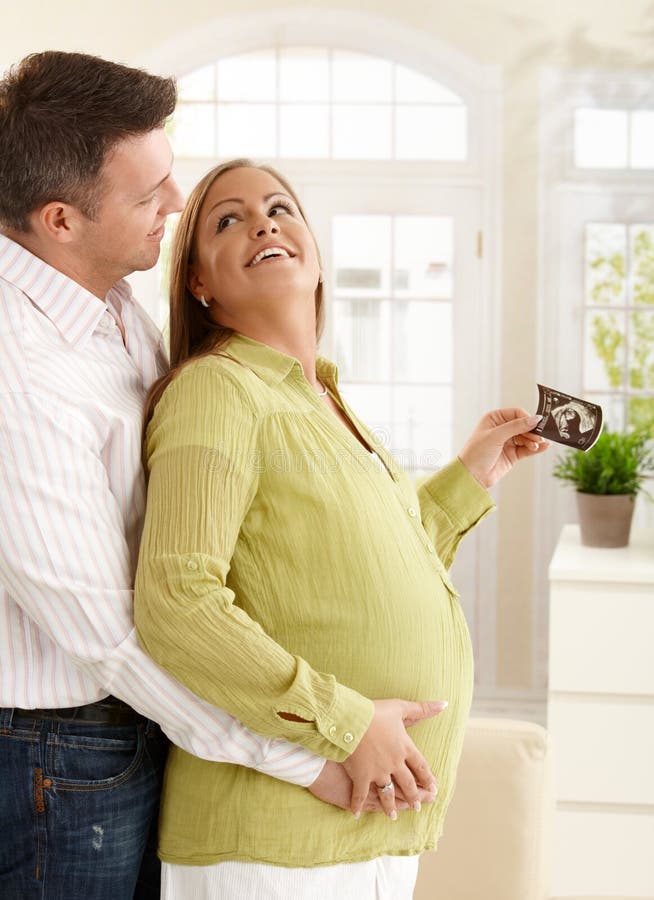 Expecting couple on sofa stock image. Image of couple - 13614793