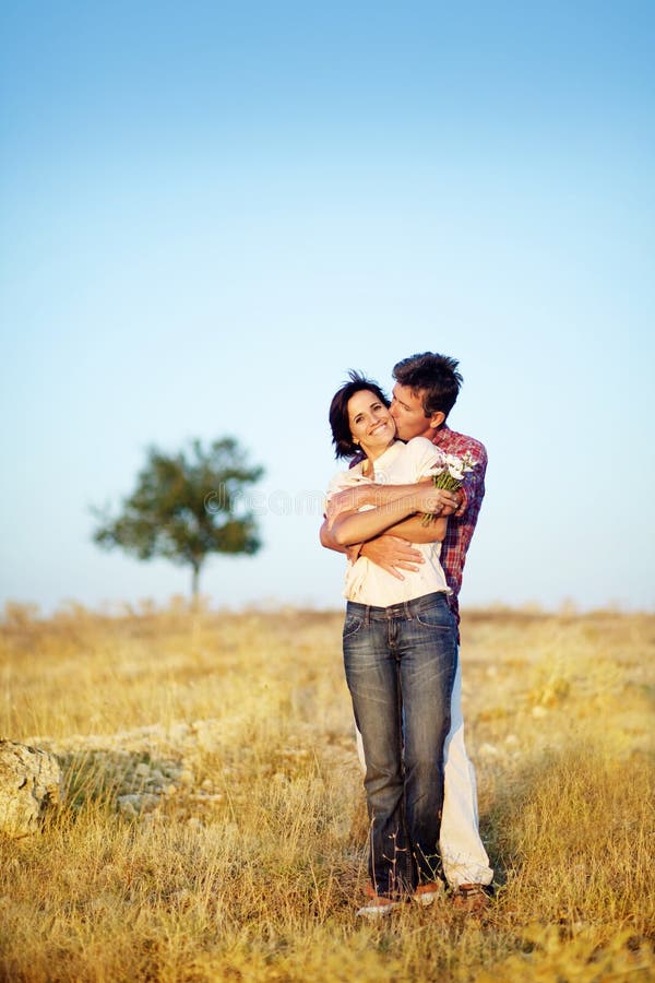 Happy couple in a field stock photo. Image of couple - 61118356