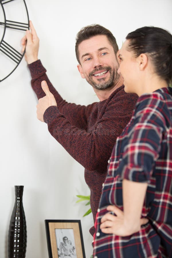 Happy Couple Hanging Clock on Wall Stock Image - Image of family, wife ...