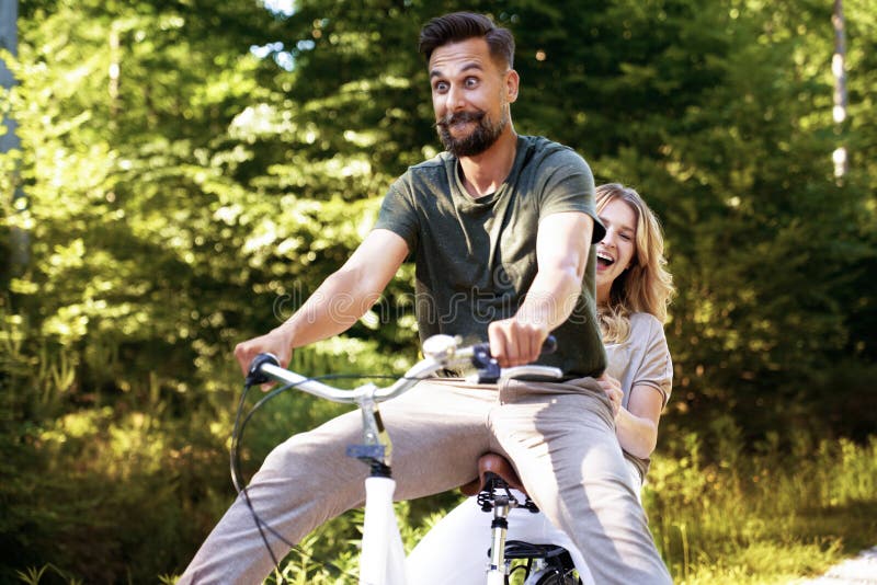 Happy Couple Having Fun on a Bike in the Woods Stock Photo - Image of ...