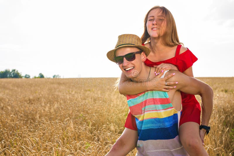 Happy Couple Having Fun Outdoors on Field. Freedom Concept. Piggyback ...