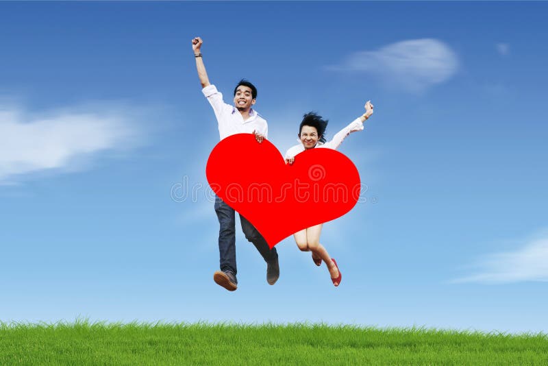 Happy Couple Jumping Against Blue Sky Stock Image - Image of attractive ...