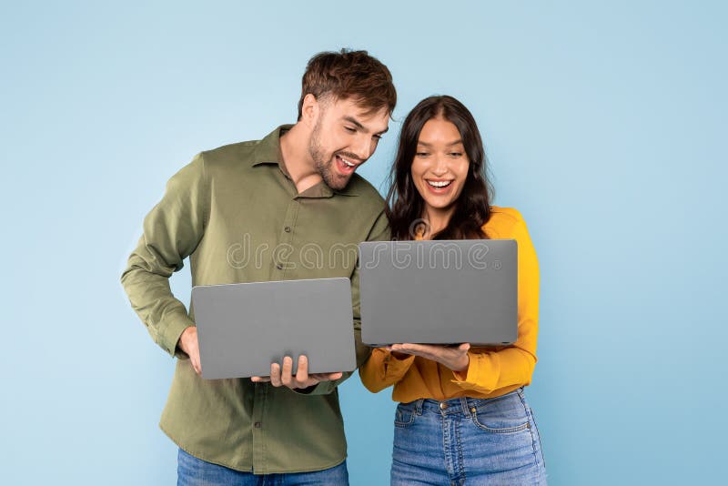 Happy Couple with Laptops Sharing a Screen on Blue Backdrop Stock Photo ...