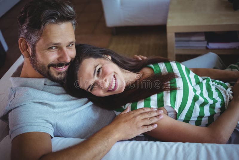 Happy Couple Lying on Sofa in Living Room Stock Image - Image of ...