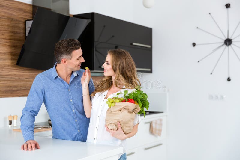 Man Flirting in the Kitchen with a Woman Stock Photo - Image of adult ...
