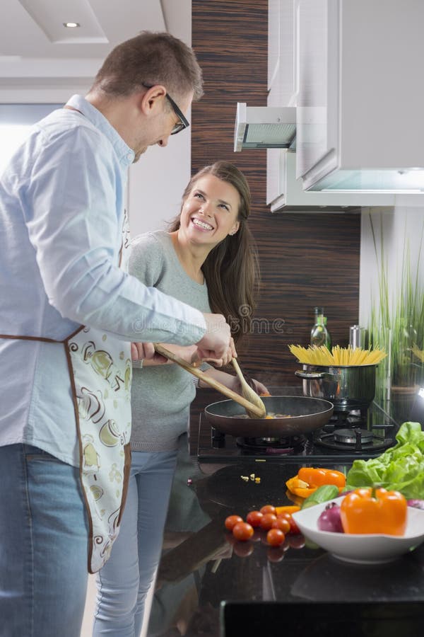 Side View of Man Tasting Food while Cooking in Kitchen Stock Image ...