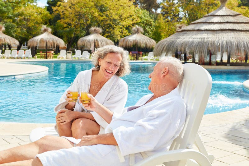 Happy Couple Seniors Sitting By The Pool By The Hotel Stock Image