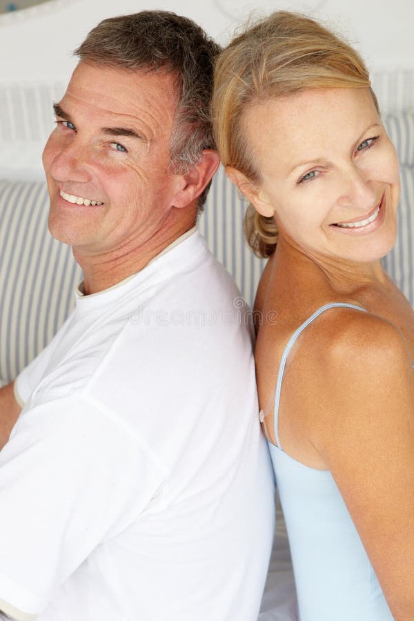Happy Couple Sitting Back To Back Stock Image - Image of forties ...